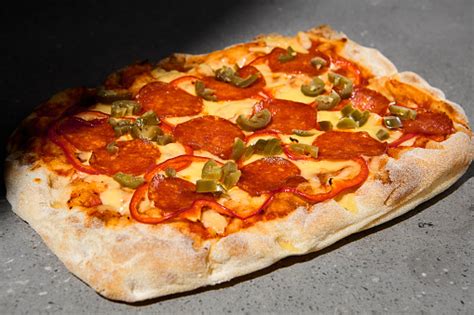 전통적인 이탈리아 음식 어두운 배경에 피자 페퍼로니 단단한 그림자가있는 회색 돌 테이블에 페퍼로니 핀사 콘크리트 배경에 페퍼로니와 할라 페노가있는 로마 피자 핀사 메뉴