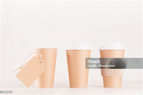 커피 포장 이랑흰색 나무 보드 커피숍 인테리어에 흰색 모자 컵 홀더 및 빈 레이블 3 갈색 공예 종이 컵의 설정 브랜드 정체성 광고 디자인에 대 한 현대 우아한 개념 0명에