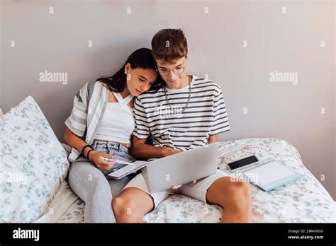 Girl Studying With Brother On Laptop In Bedroom At Home Stock Photo Alamy