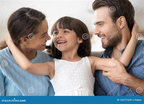 Семья портрета счастливая привлекательная молодая представляя обнимать Стоковое Изображение