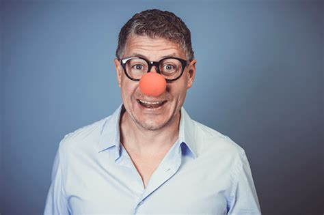 파란색 셔츠와 검은 색 안경과 파란색 배경 앞에서 포즈를 취하는 빨간 광대 코를 가진 사업가 40 44세에 대한 스톡 사진 및 기타 이미지 Istock