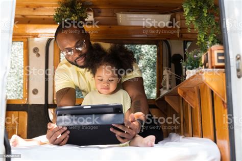 아프리카 계 미국인 아버지는 집에서 디지털 태블릿을 사용하여 딸을 가르칩니다 집에서 함께 시간을 보내는 아프리카계 미국인 가족 교육 및 기술 개념 2 3 살에 대한 스톡