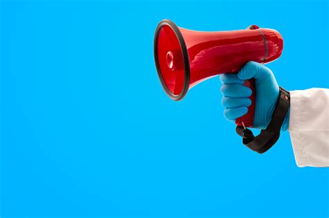 라텍스 보호 장갑과 흰색 실험실 코트에 메딕 손으로 의사 조언 및 의료 발표 개념 클리핑 경로 컷 아웃 및 복사 공간 파란색 배경에 고립 된 메가 폰을 들고 의사에 대한