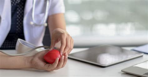 검사실에서 붉은 심장을 들고 있는 환자의 혈압을 측정하는 젊은 여성 의사의 모습을 클로즈업 사진 Unsplash의 태국 이미지