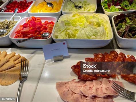클로즈업 이미지 호텔 셀프 서비스 뷔페 디스플레이 샐러드 바의 콜드 컷 고기 빨간색과 노란색 피망 그릇 외에 햄과 살라미 조각 방울 토마토와 양상추 잎 자체 제작 샐러드