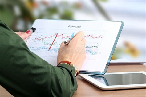 Young Businesswoman Working In The Office Sitting At Her Desk Analyzing Data In Graphics