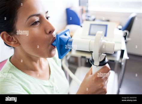 Lung Function Test Patient Blowing Into A Peak Flow Spirometer During