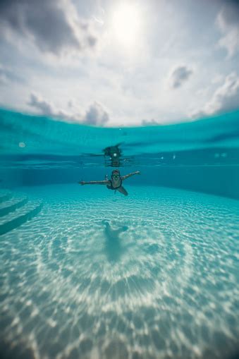 햇살이 내리쬐는 청록색 바다를 통해 수중에서 미끄러지듯 수영하는 사람 분할 전망 수영장 탈출 10 11세에 대한 스톡 사진 및 기타 이미지 Istock