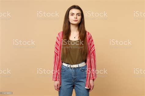 캐주얼 서 있는 아름 다운 젊은 여자의 초상화와 스튜디오에서 파스텔 베이 지 벽 배경에 고립 된 찾고 카메라 사람들은 진심으로 감정 라이프 스타일 개념입니다 복사 공간을