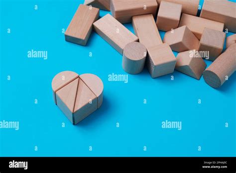A Heart Made With Some Wooden Building Blocks On A Blue Background Next