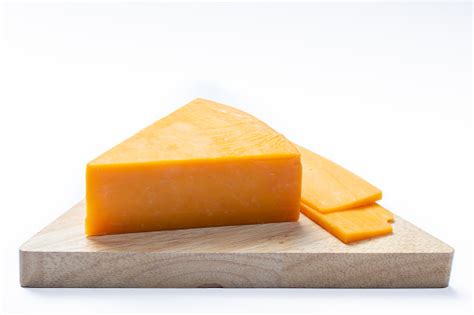 Piece Of Hard Orange Cheddar Cheese On Wooden Cheese Plank Isolated