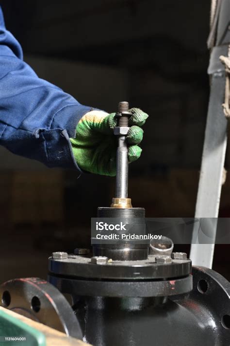 밸브의 베이스는 공장에서 조립 하기 위해 바이스에 설치 되 고 클램핑 되며 작업자는 구성품을 설치 하 고 고정 합니다 강철에 대한 스톡 사진 및 기타 이미지 Istock