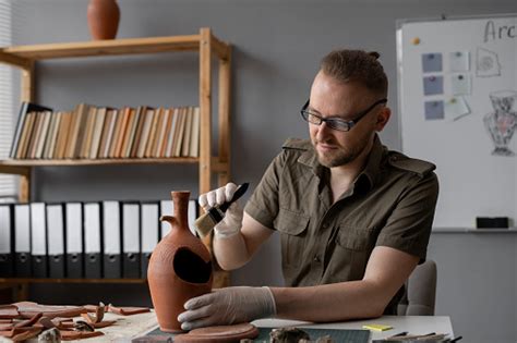 고고학자는 사무실에서 일하며 발견 된 고대 문명 문화 유물을 연구하고 브러시로 청소합니다 35 39세에 대한 스톡 사진 및 기타 이미지 35 39세 고고학 고고학자
