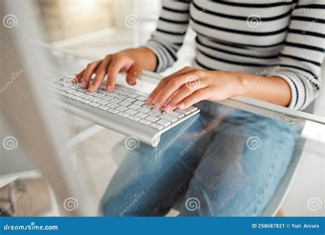 Businessperson Typing On A Keyboard Working On A Desktop Computer While Sitting At A Desk At