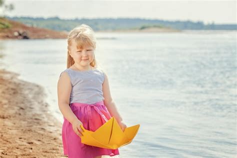 Premium Photo Nice Blonde Girl Posing With Homemade Paper Boat
