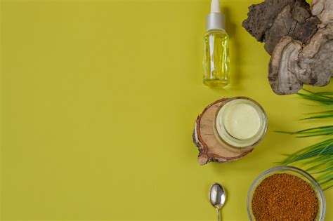 차가 자작나무 버섯은 화장품의 유행 개념입니다 천연 크림 노란색 배경에 유리 용기에 차가와 에센셜 오일 스파 천연 항산화제 플랫