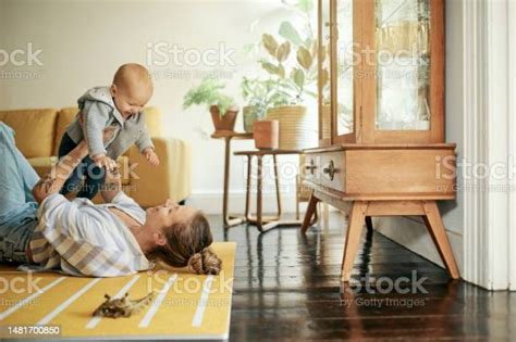 가족 놀이 및 엄마는 집에서 아기를 들어 올려 유대감을 형성하고 양질의 시간을 보내고 바닥에서 함께 휴식을 취합니다 거실 사랑 행복한 엄마와 함께 주말에 아이 발달 보살핌