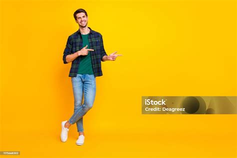 카피 스페이스 전체 길이 바디 사이즈 사진 데님 청바지 체크 무늬 셔츠 신발을 입고 활기찬 색상 배경을 통해 고립 된 빈 공간에서 눈을 묻는 쾌활한 잘 생긴 남자의 사진