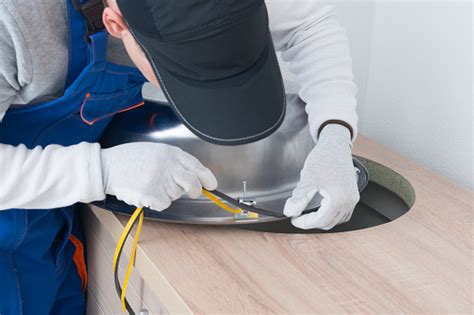 보호복을 입은 가구 조립기 카운터탑과 금속 싱크대 사이의 수분을 제거하기 위해 밀봉 테이프를 접착제 35 39세에 대한 스톡