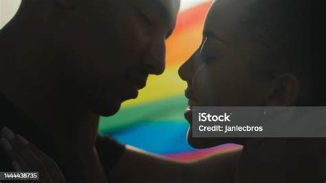 Lgbt 프라이드 축하 무지개 깃발 앞에서 낭만적인 포옹에 서 있는 유색인종 퀴어 Lgbt 프라이드의 달에 대한 스톡 사진 및 기타 이미지 Lgbt 프라이드의 달