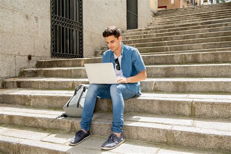 스마트 캐주얼 야외 계단에 앉아 도시에서 랩톱 컴퓨터를 사용 하 여 젊은 잘생긴 현대 남자가 있다 학생 프리랜서 서핑 Net