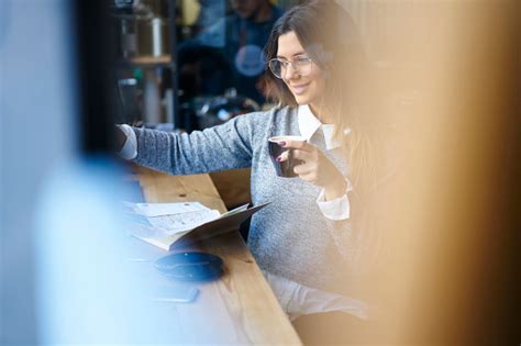 아늑한 카페 인테리어 앉아 흐리게 손가락 근처에 자유 시간을 보내고 즐기는 명랑 Hipster 여자 표시등 정면 매력적인 여성 기자 컵에 뜨거운 커피를 들고 하는 좋은