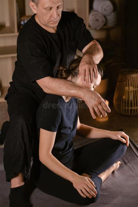 Client In Thai Massage Session With Therapist A Man Giving A Thai Neck Massage To A Girl In A