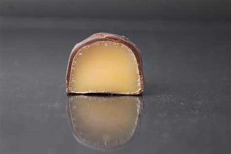 노란색 갈색 과일 충전 프랄린이 있는 섹션의 초콜릿 케이스 사탕 검은 배경에 초콜릿 클로즈업의 마멀레이드 젤리 사탕 초콜릿 캔디 데이 휴일에 무엇을 줄지 먹거리가있는 사탕은