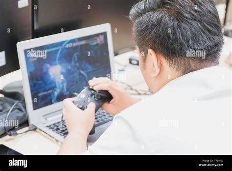 Back Of Asian University Student Playing Game In The Classroom During Back Of Asian University Student Playing Game In The Classroom During