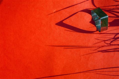 무료 사진 짙은 빨간색 표면에 금속 하트 모양의 쿠키 커터의 그림자