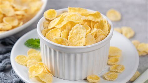 옥수수 플레이크는 회색 시멘트 배경에 우유와 과자를 그릇 닫고 신선하고 건강한 아침 식사 디자인 개념 0명에 대한 스톡 사진 및