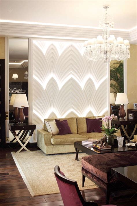 Гостиная с резной стеновой панелью цвета слоновой кости оборудованной подсветкой