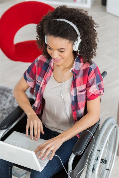 Disabled Lady Using Notepad Computer And Wearing Headphones Stock Image