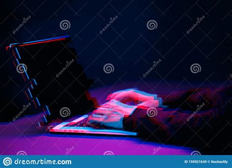 Hacker In The Hood Working With Laptop Typing Text In Dark Room Image