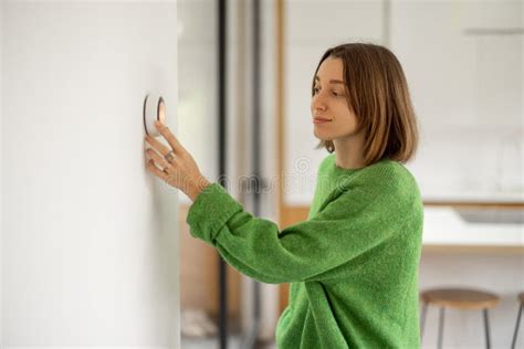 Woman Controlling Temperature With A Smart Thermostat At Modern Apartment Stock Photo Image