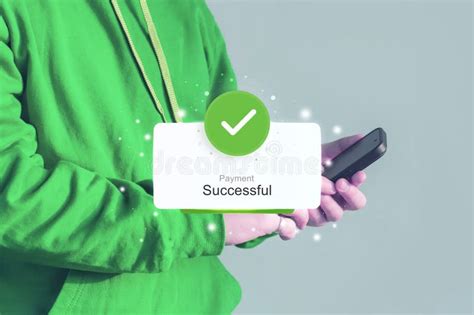 Man Holds A Smartphone Displaying A Payment Successful Notification With A Green Checkmark