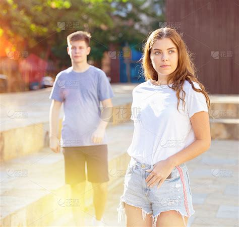 女孩站着，男孩跟在她后面走