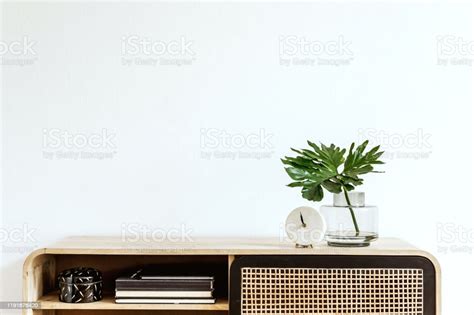 세련된 Commode 꽃병에 열대 잎 책 흰색 시계와 우아한 액세서리와 스칸디나비아 아파트에서 거실의 인테리어 디자인 현대적인 홈 장식 템플릿 공간을 복사합니다 흰색