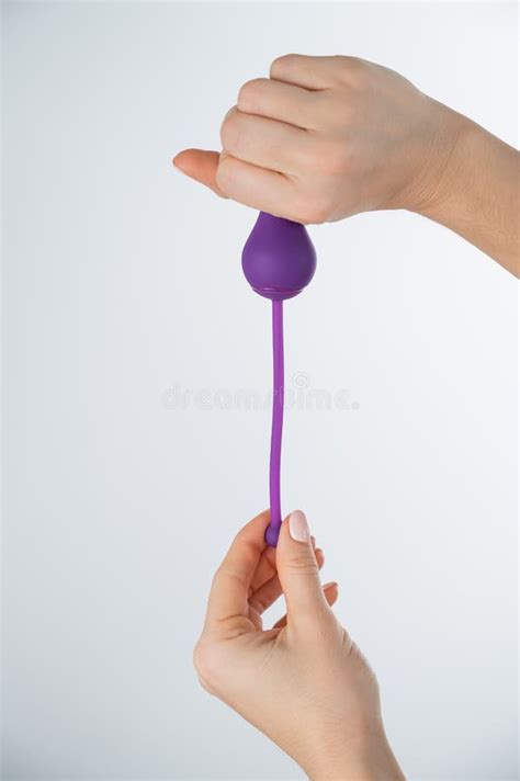 A Faceless Woman Holding An Electronic Kegel Trainer For Training