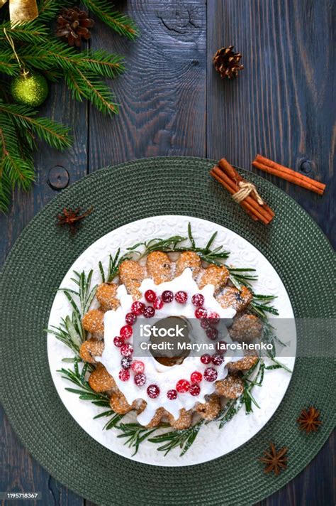 흰색 접시에 크리스마스 과일 케이크입니다 나무 소박한 배경에 로즈마리 가루 설탕과 링곤 베리로 장식 된 수제 과일 케이크 맨 위 보기 12월에 대한 스톡 사진 및 기타