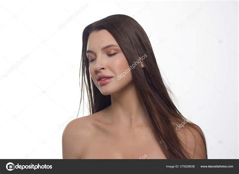 美丽的姑娘 长着一双大眼睛 深色的眉毛 光秃秃的肩膀 看着相机 面带微笑 模特儿的裸体妆容 美丽的照片 雪白的笑容和耳朵上的装饰 图库照片ymka jane mail ru