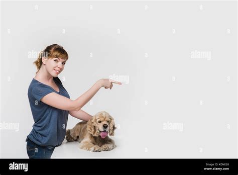 A Woman With Her American Cocker Spaniel Pointing To Space At Right
