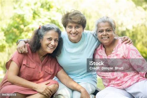 야외에서 함께 즐거운 시간을 보내는 행복한 인도 노인 여성 여름 공원에서 서로 껴안고 있는 노인들 인도 문화에 대한 스톡 사진