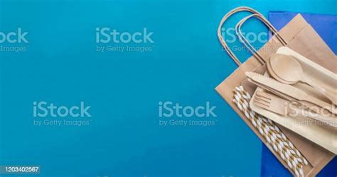 나무 대나무 칼 포크 숟가락 칼 주스 캔에서 재활용 식기와 플라스틱 무료 세트 산림 친화적인 재활용 종이 봉투 상단 보기 폐기물 제로 친환경 컨셉 플랫 레이 트렌디한 블루