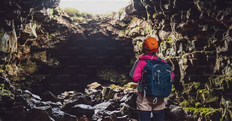 여성 여행자는 아이슬란드의 용암 터널을 탐험합니다 라우파르홀셸리르는 아름다운 숨겨진 동굴 세계입니다 아이슬란드 유럽에서