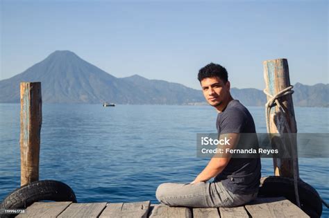 과테말라의 푸른 호수에서 관광 관광지 낙원 아티틀란 과테말라 호수의 부두에 앉아 젊은 히스패닉 남자 걷기에 대한 스톡 사진 및 기타 이미지 Istock