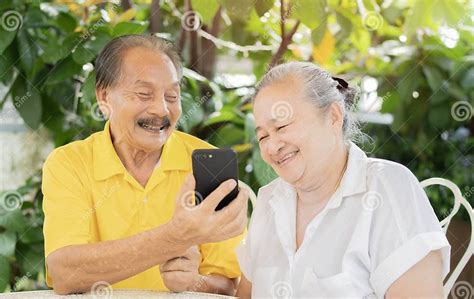 Elderly Asian Grandfather And Grandmother Spend Time Having Fun Using