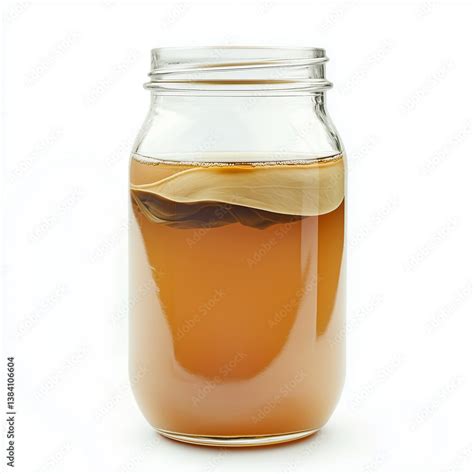 Glass Jar Of Kombucha With Scoby In Amber Liquid On White Background In