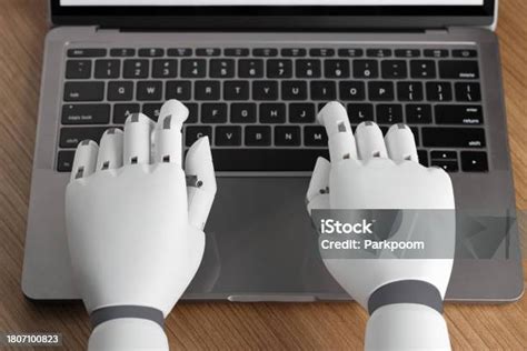 로봇은 컴퓨터 키보드에서 손가락으로 입력하거나 Enter 키를 누릅니다 노트북으로 작업하는 사이보그 기계 팔 인공 지능 미래 지향적 디자인 또는 챗봇 개념 0명에 대한 스톡