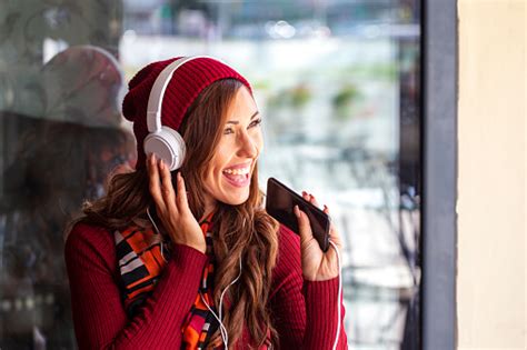 머리에 모자를 쓴 빨간 여성이 음악을 듣고 현지 카페에서 헤드폰을 즐기세요 25 29세에 대한 스톡 사진 및 기타 이미지 25 29세 갈색 머리 감정 Istock
